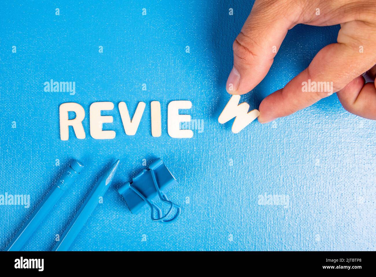 Review. Text from white wooden letters on a blue background Stock Photo ...
