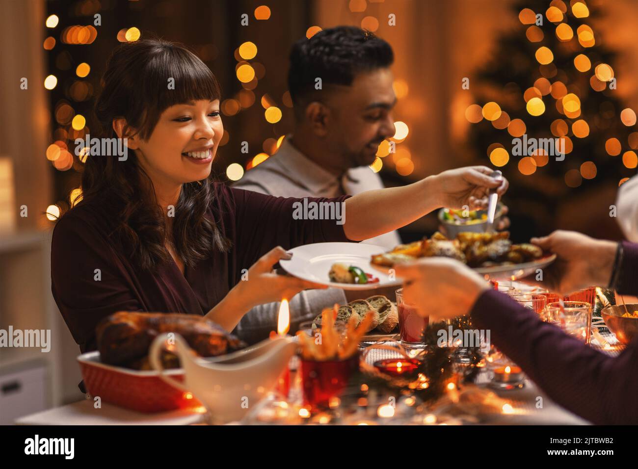 happy friends having christmas dinner at home Stock Photo - Alamy