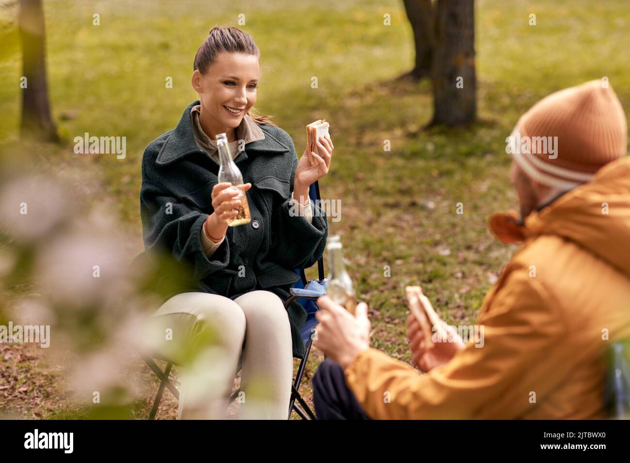 couple drinking beer with sandwiches at tent camp Stock Photo - Alamy