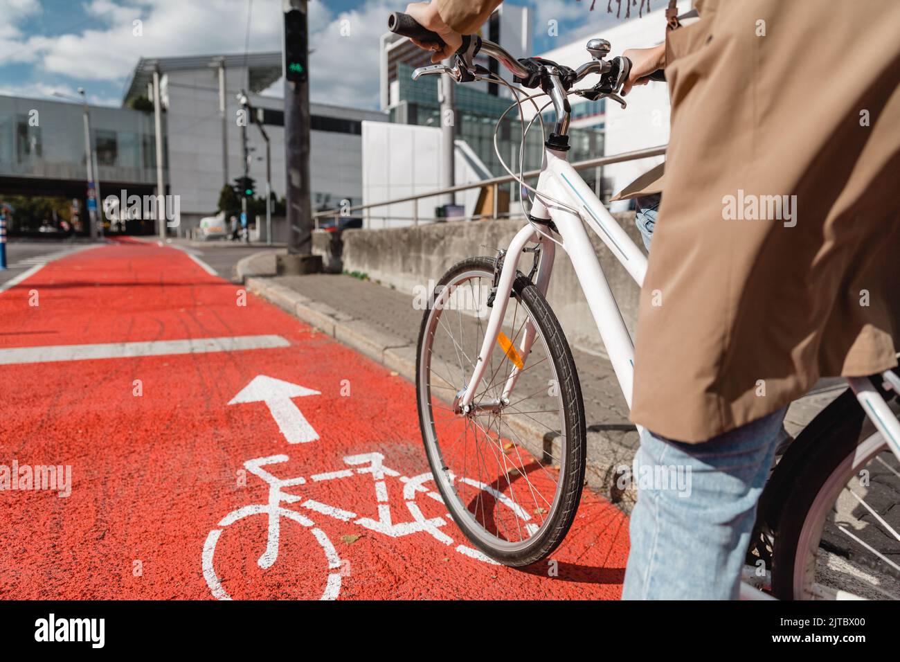 woman cycling along red bike lane road in city Stock Photo - Alamy