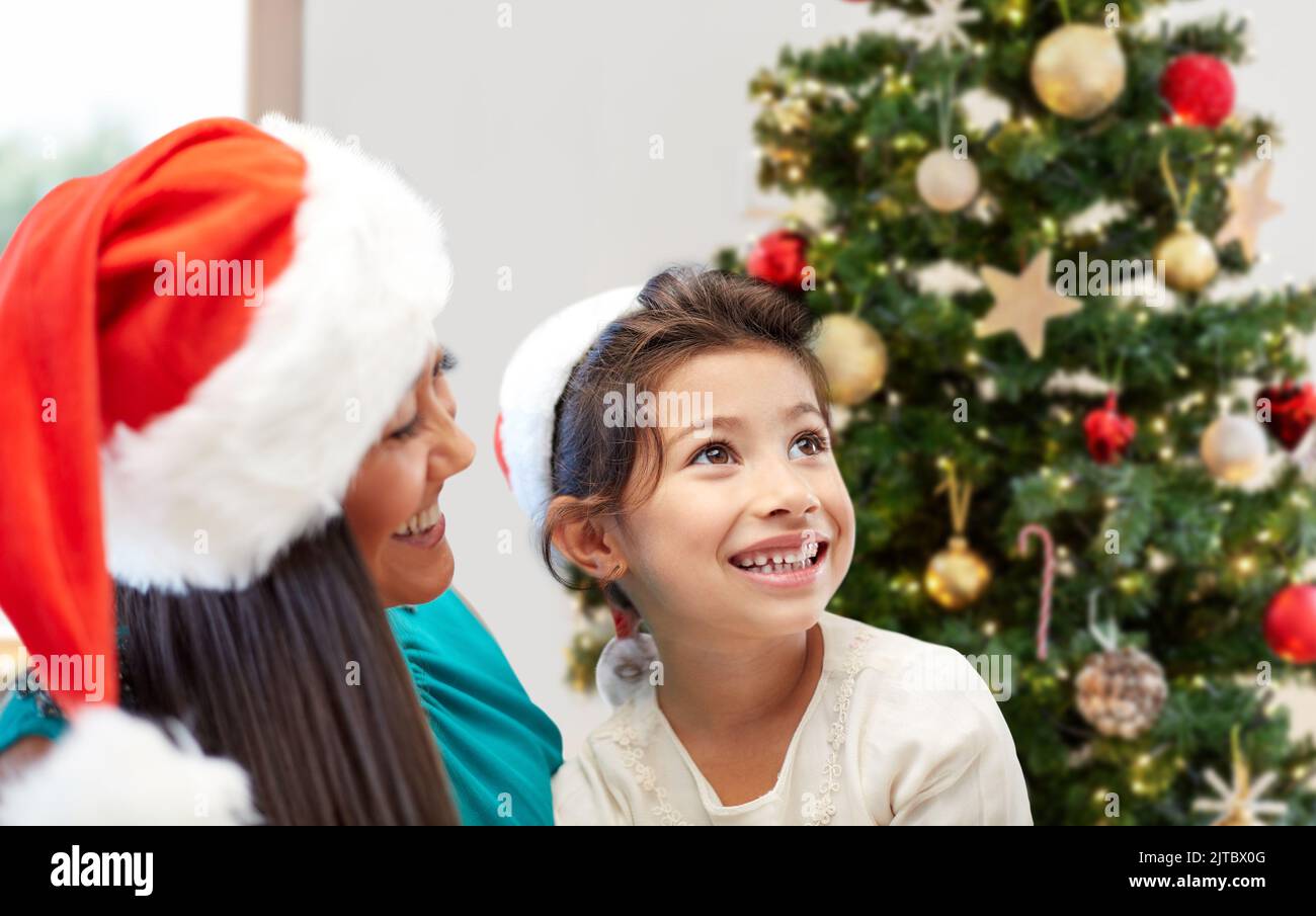 happy mother and little girl in santa hats at home Stock Photo - Alamy