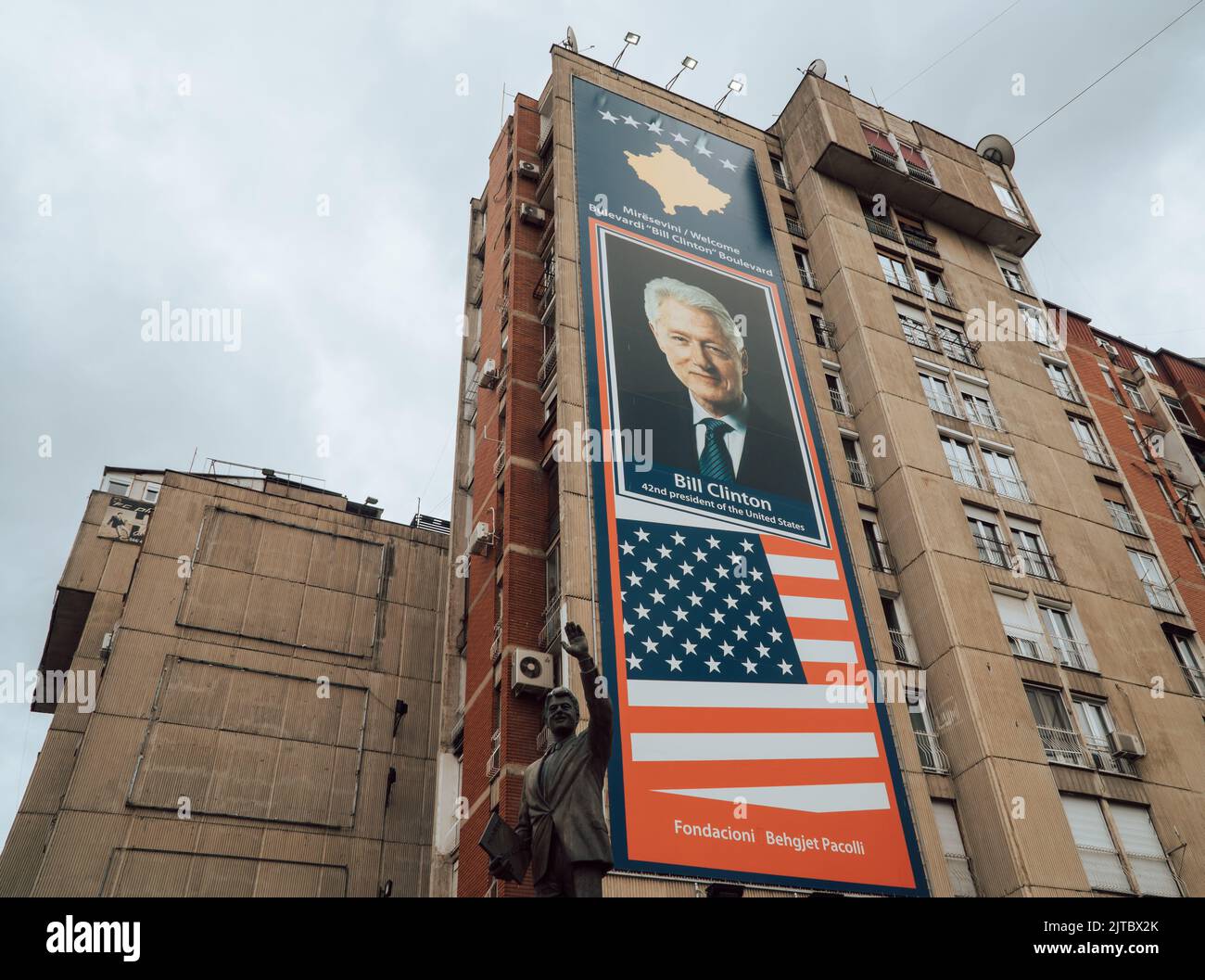 A low-angle shot of Bill Clinton banner and statue in downtown Pristina ...