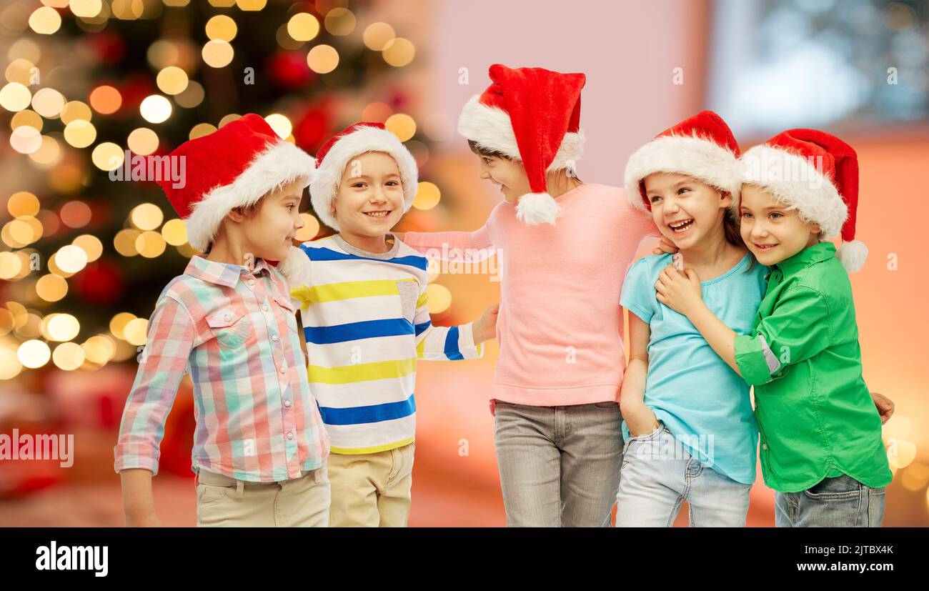 happy little children in santa hats hugging Stock Photo - Alamy