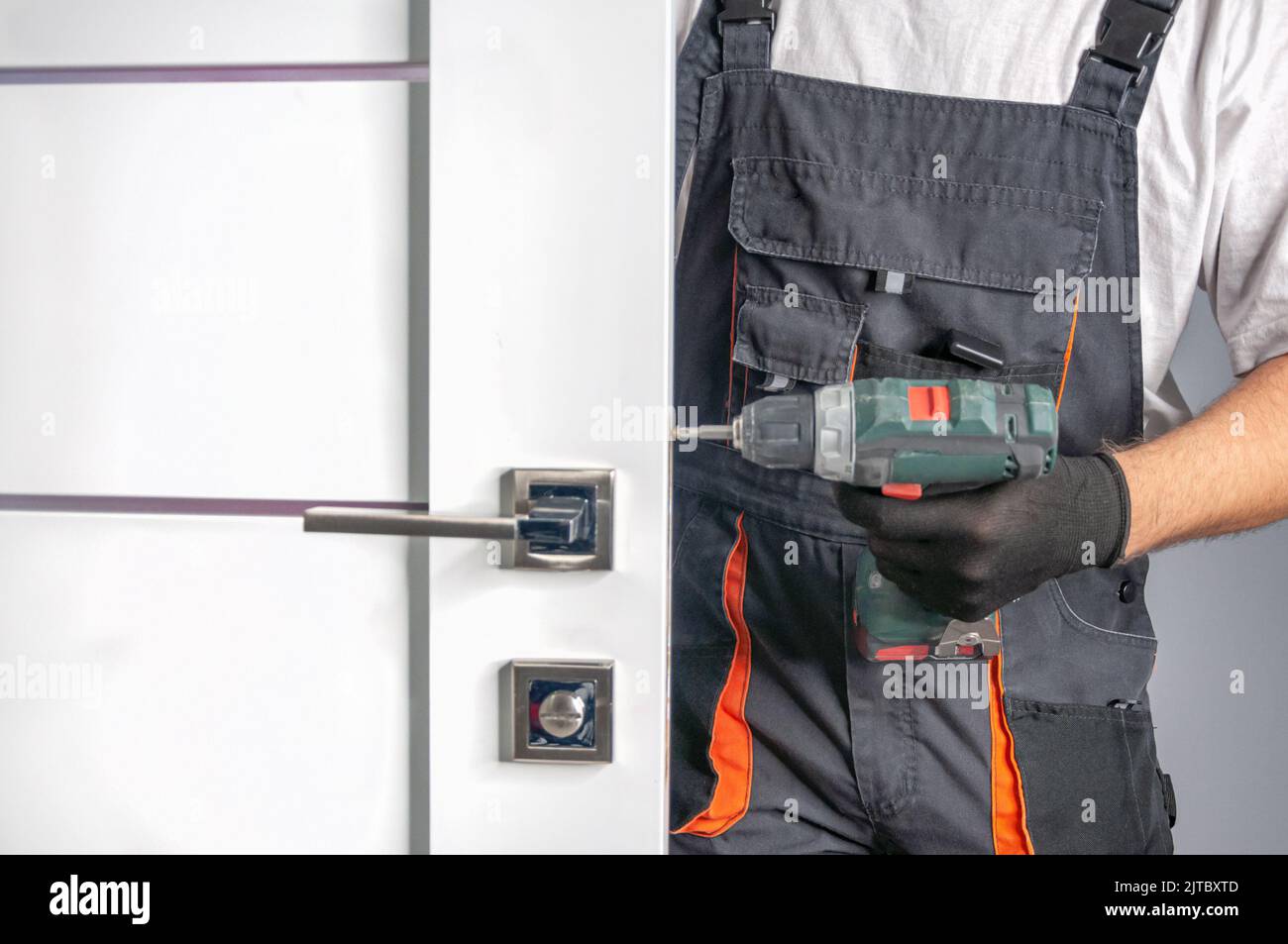 master installs a door lock in the room Stock Photo - Alamy