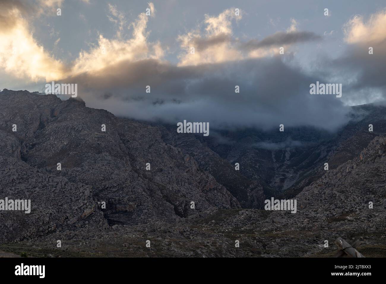 Cloudy view of a high mountain covered with fog Stock Photo - Alamy