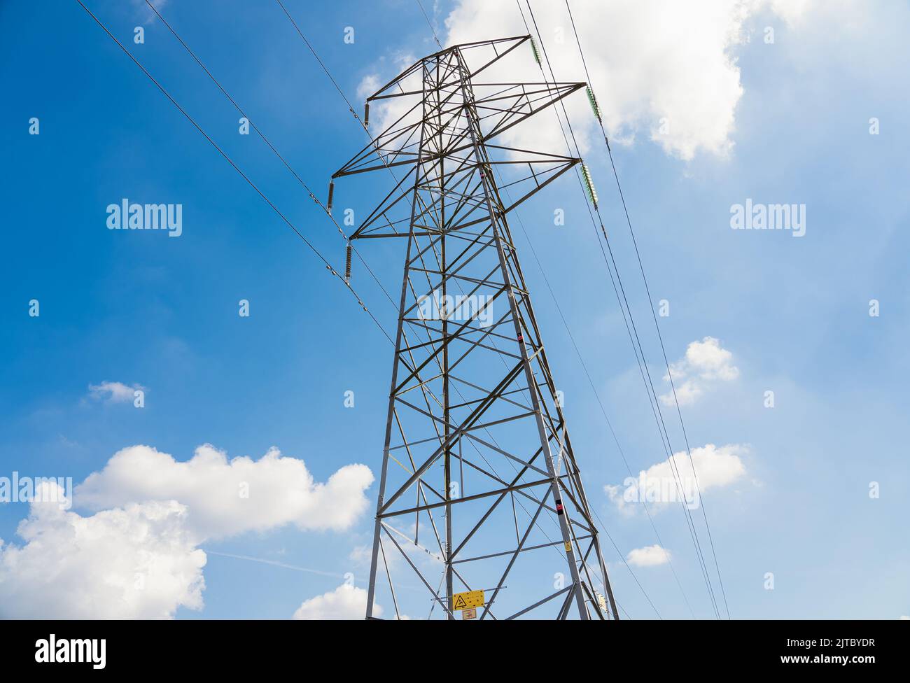 close-up of electricity power pylon and cables against a bright blue ...