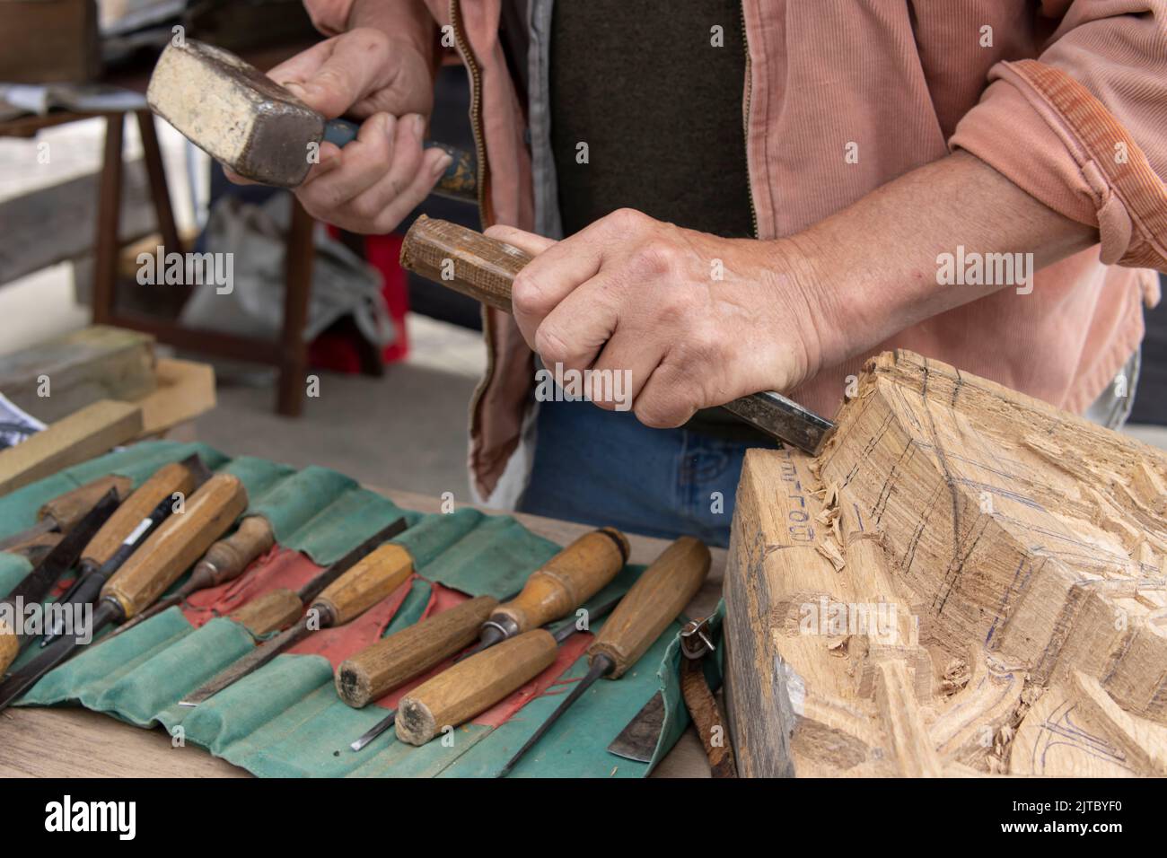a man makes products from a tree with his own hands and with a tool ...