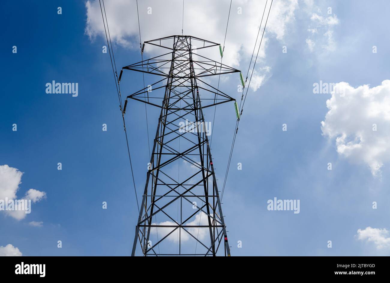 close-up of electricity power pylon and cables against a bright blue ...