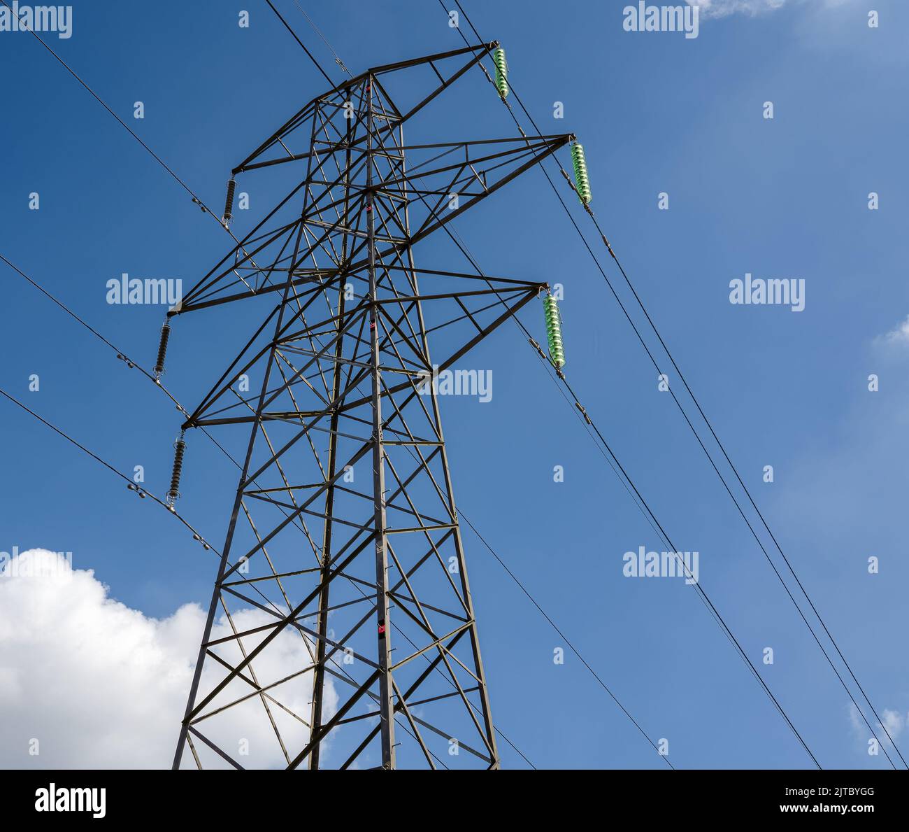 close-up of electricity power pylon and cables against a bright blue ...