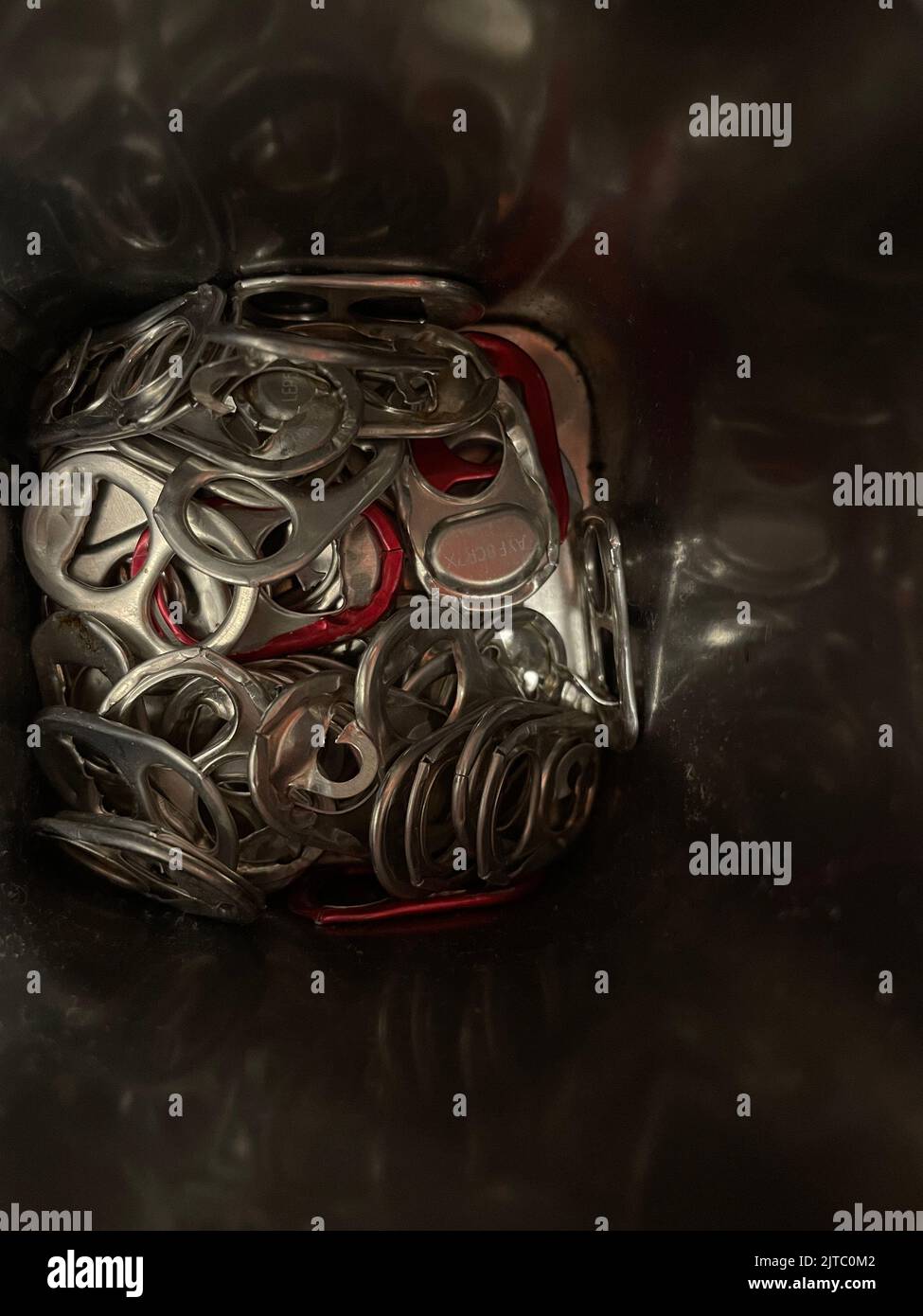 A vertical closeup shot of a bunch of soda ring pulls in a ball Stock ...