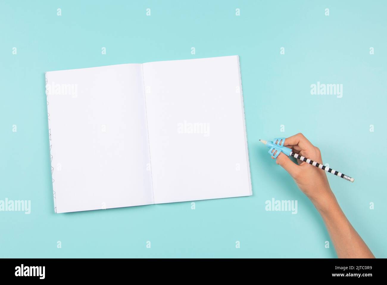 Kid hand using pencil with silicone three finger pen. Top view to hand ...