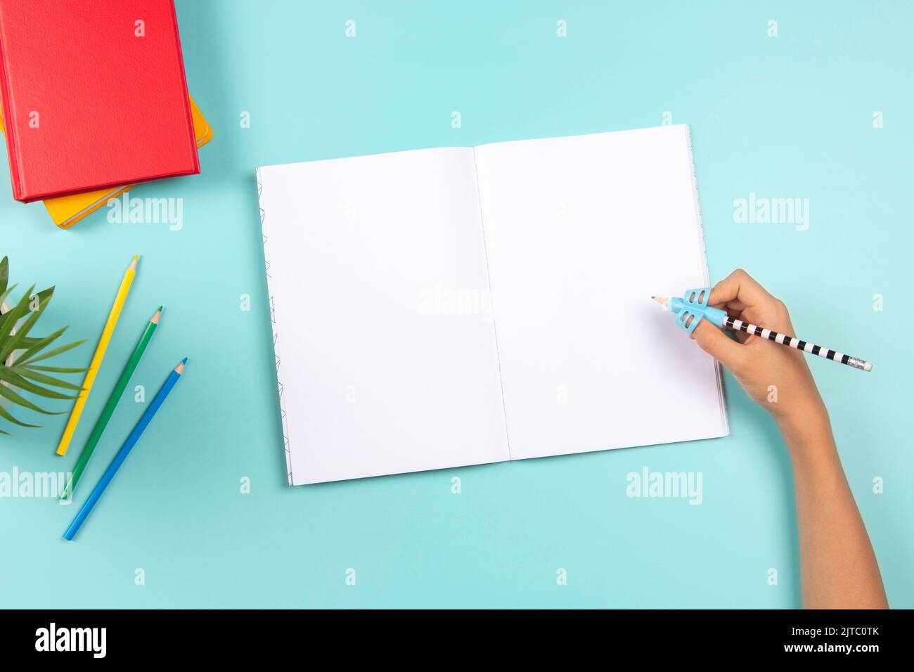 Kid hand using pencil with silicone three finger pen. Top view to hand ...