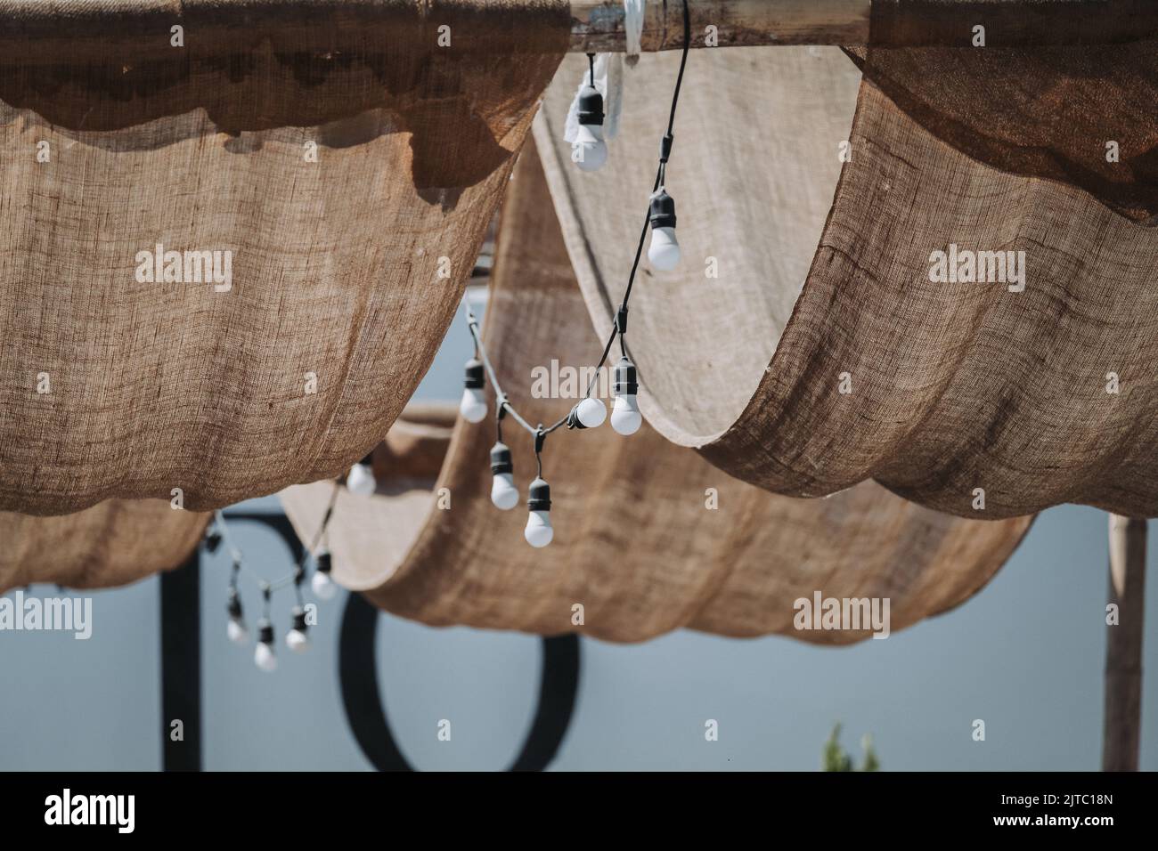 A beautiful shot of outdoor ceiling with fabrics and light bulbs in ...