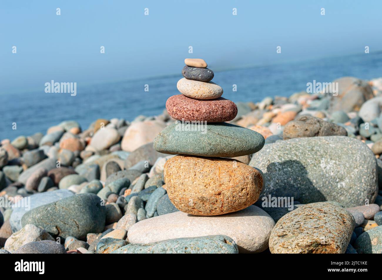 Colorful stones are naturally balanced on the background of the sea ...