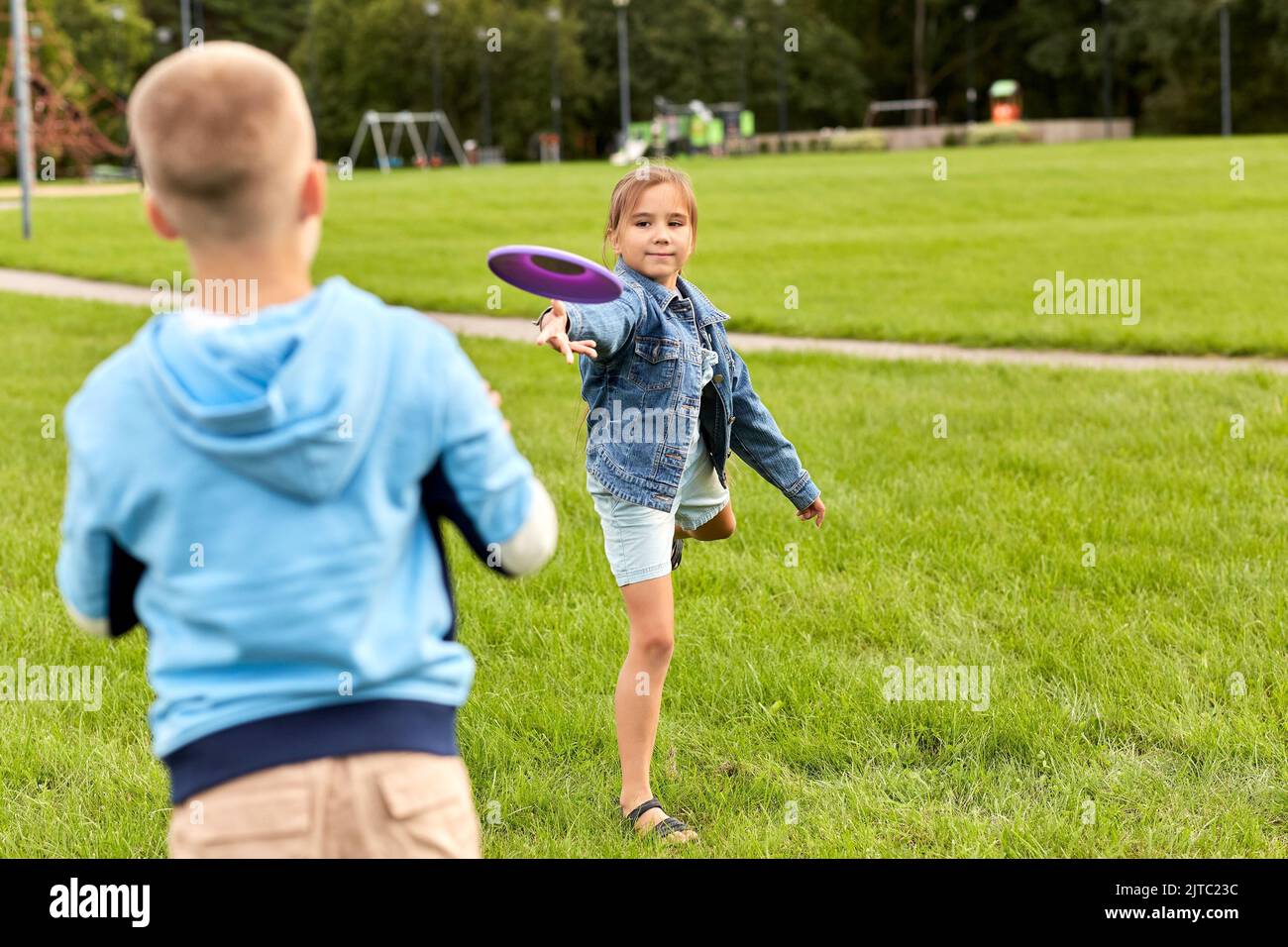 happy children playing with flying disc at park Stock Photo - Alamy