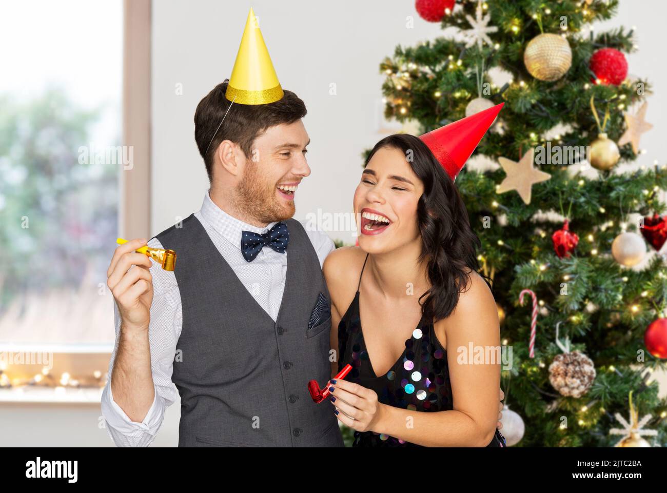 happy couple with party blowers on christmas Stock Photo - Alamy