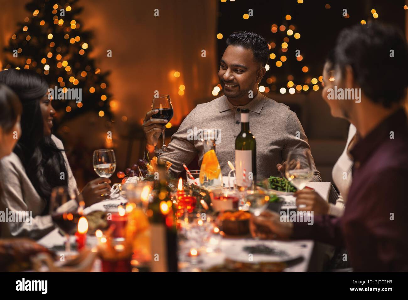 happy friends drinking wine at christmas party Stock Photo - Alamy
