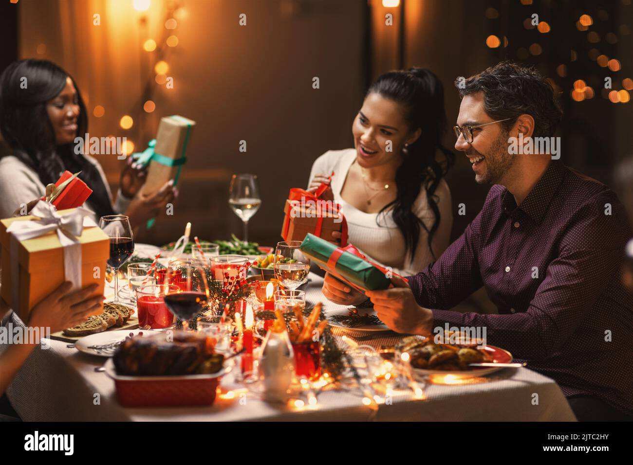 happy friends giving christmas presents at home Stock Photo - Alamy