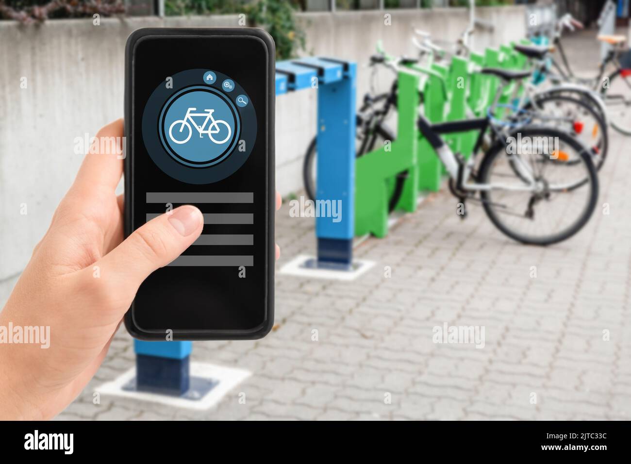 hand with phone at electric bike charging station Stock Photo - Alamy