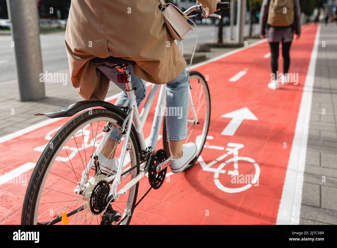 woman cycling behind pedestrian along bike lane Stock Photo - Alamy