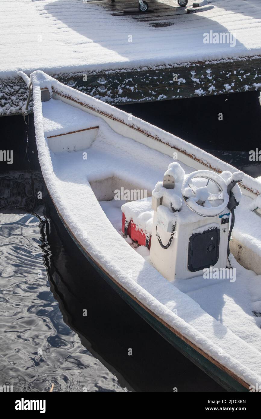 A vertical of a boat covered in snow along the Charles river Stock ...