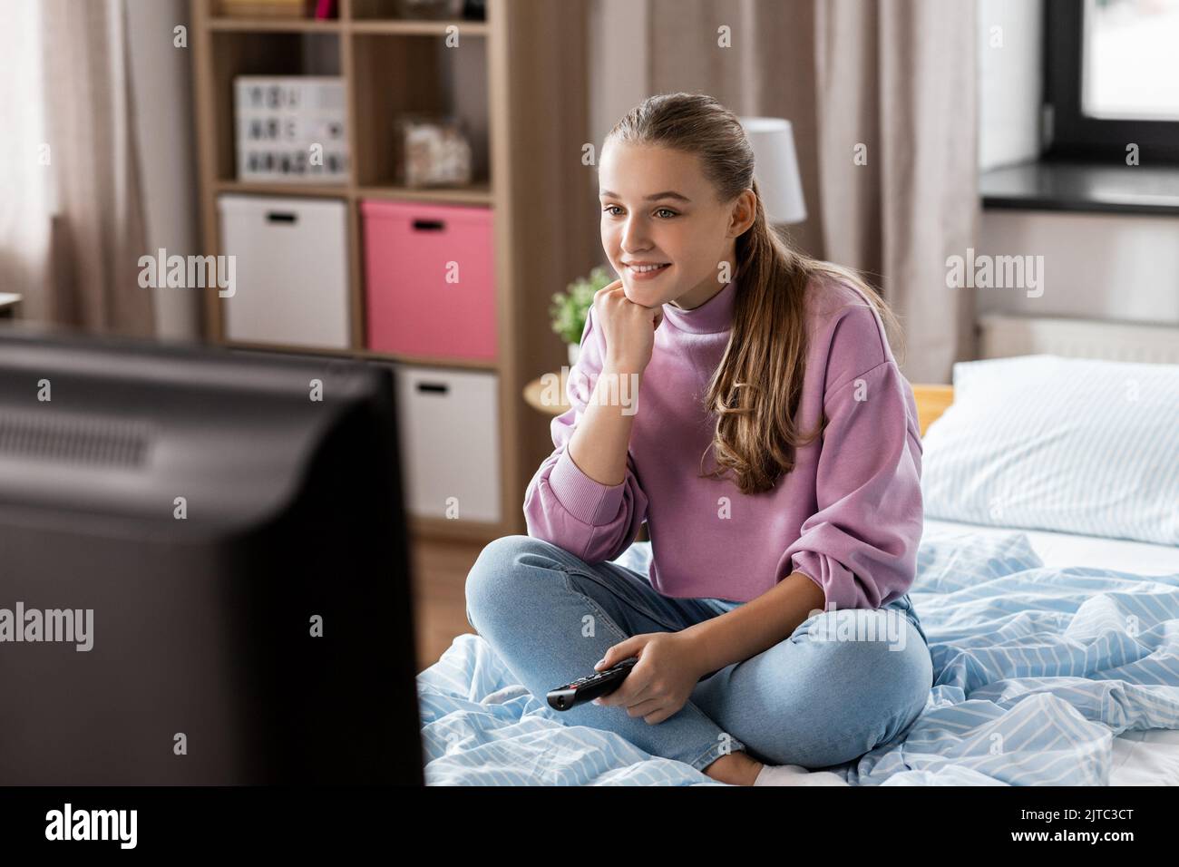 happy smiling girl watching tv at home Stock Photo - Alamy