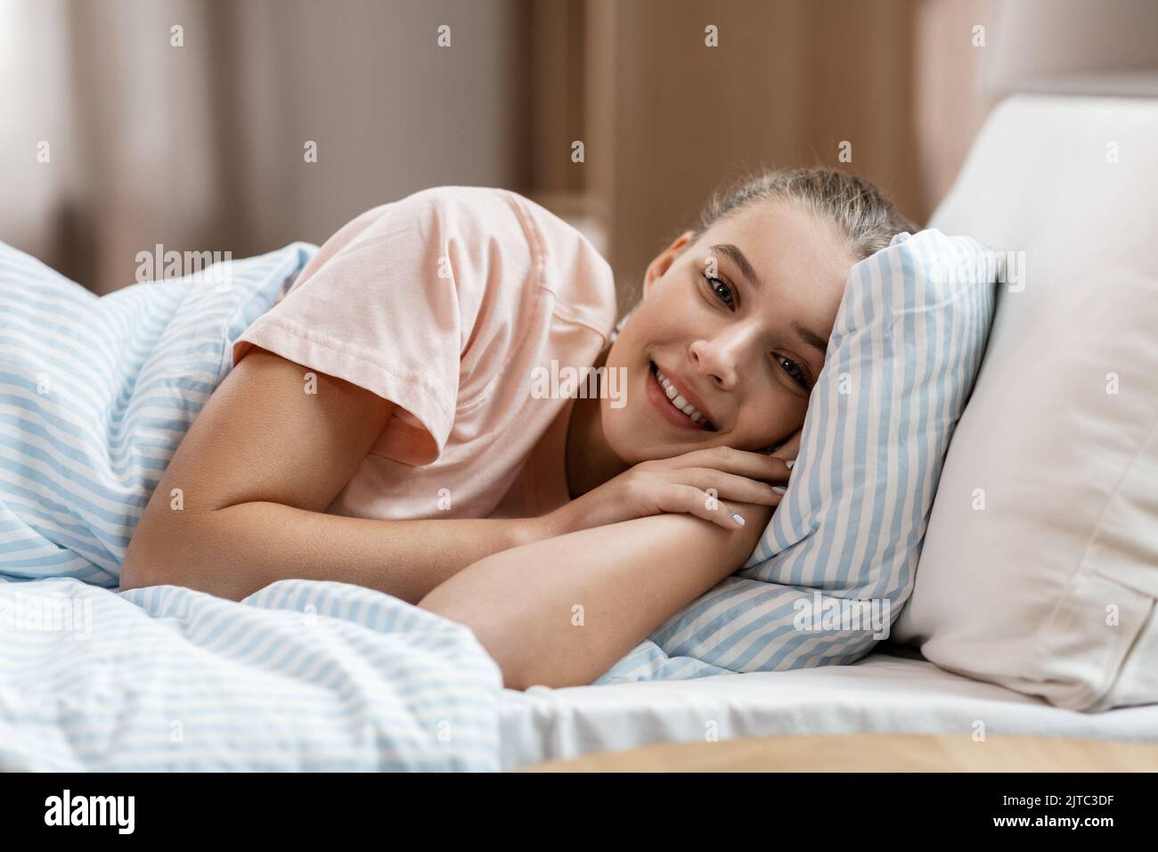happy smiling awake girl lying in bed at home Stock Photo - Alamy