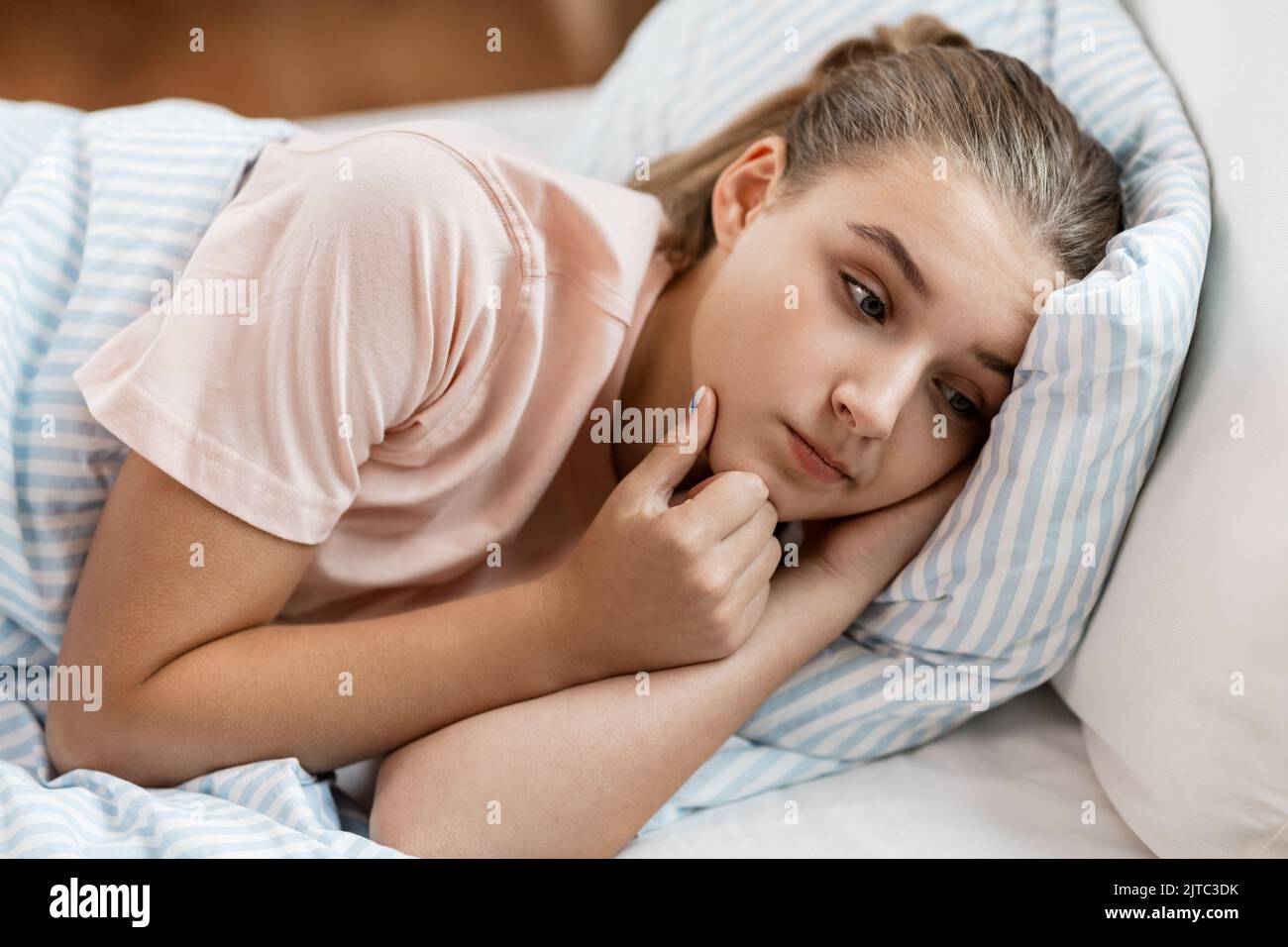 Upset teen girl in bed hi-res stock photography and images - Alamy