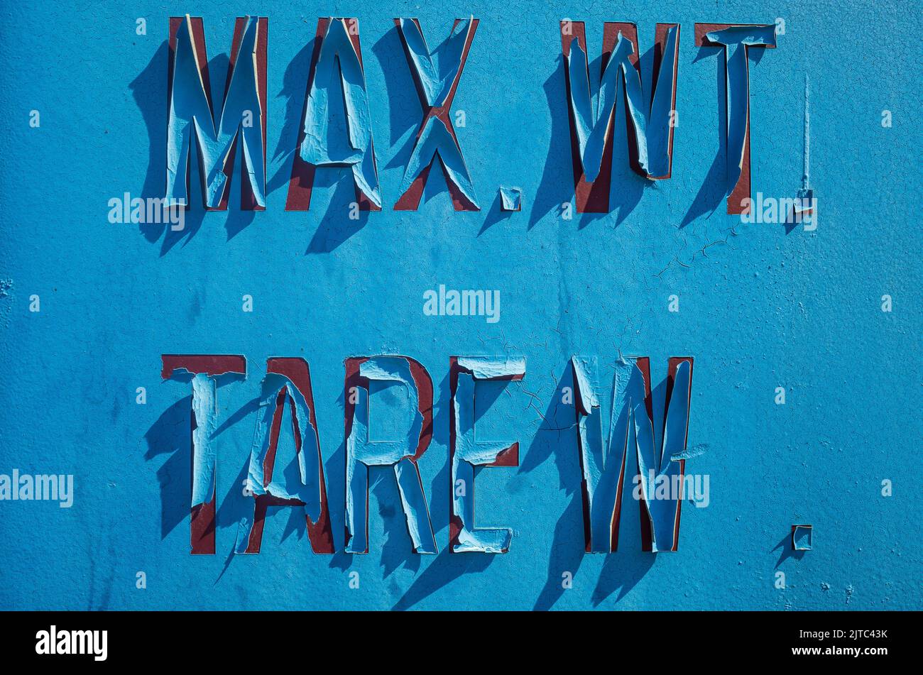 The old blue paint with letters and numbers is peeling off, dirty ...