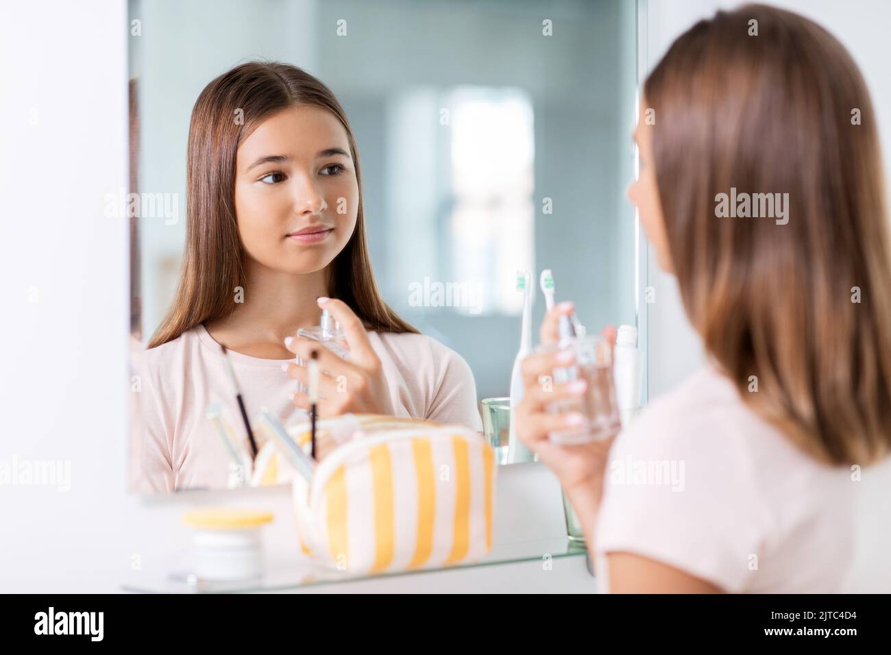 teenage girl spraying perfume at bathroom Stock Photo - Alamy