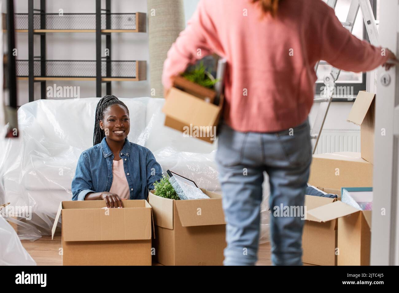 woman unpacking boxes and moving to new home Stock Photo - Alamy