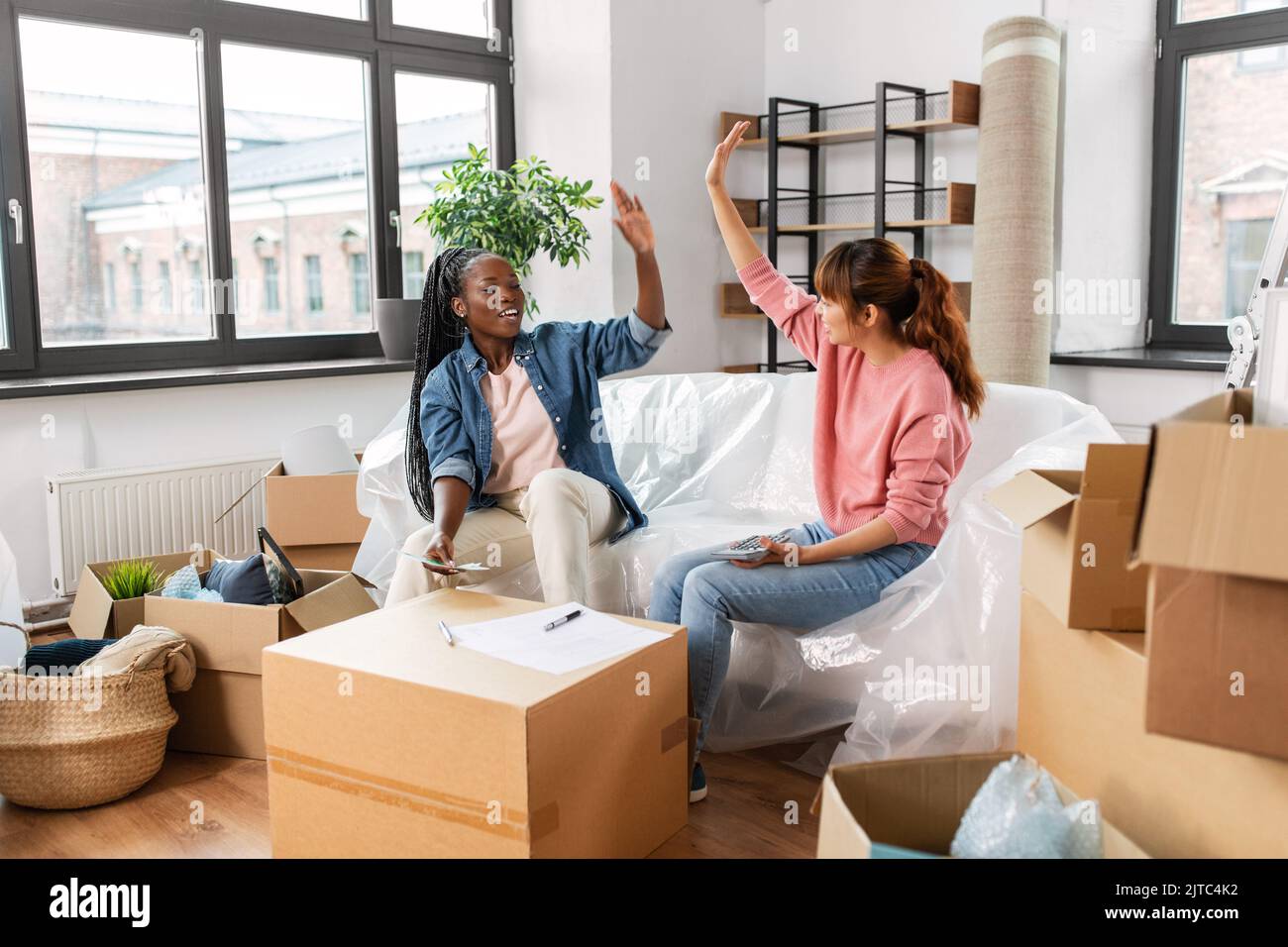 happy women moving to new home and counting money Stock Photo - Alamy