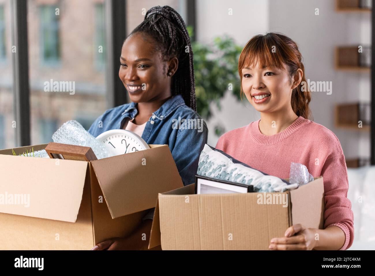 women with boxes moving to new home Stock Photo - Alamy