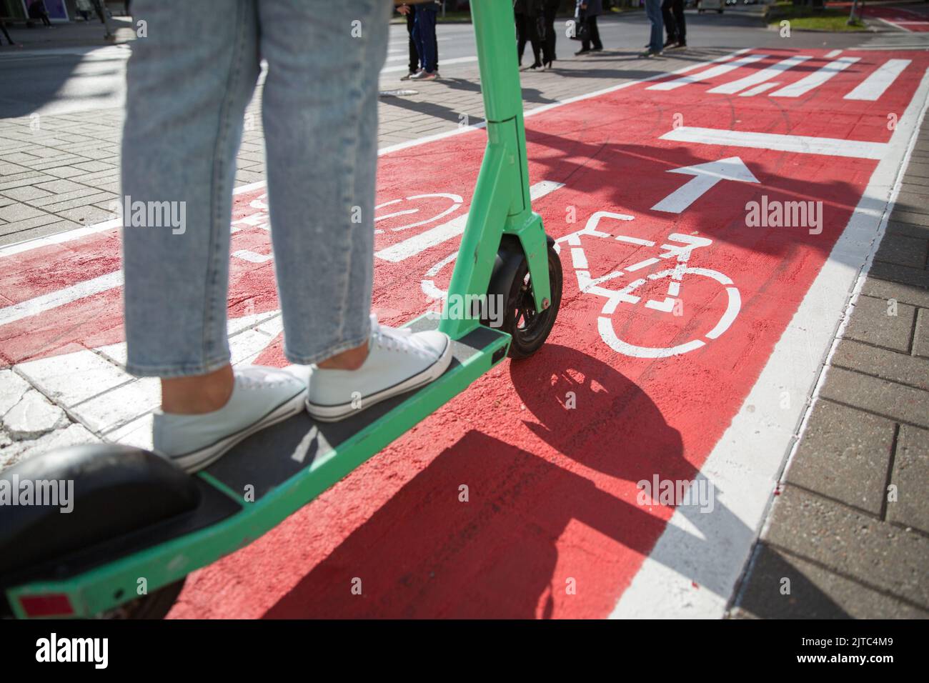 woman riding scooter along bike lane road in city Stock Photo - Alamy