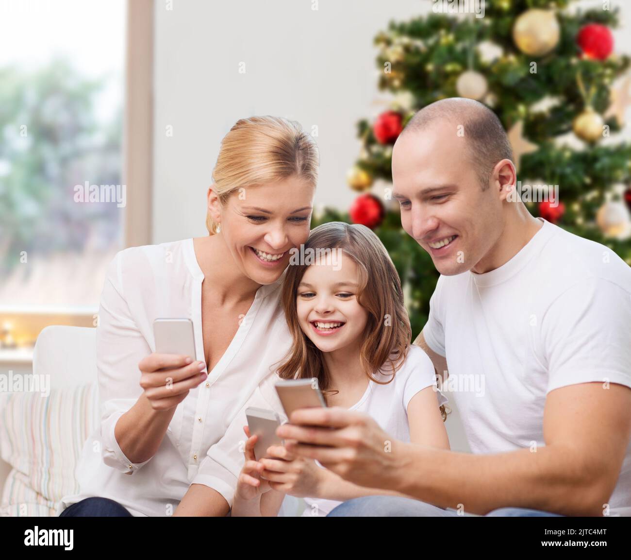 happy family with smartphones at home on christmas Stock Photo - Alamy