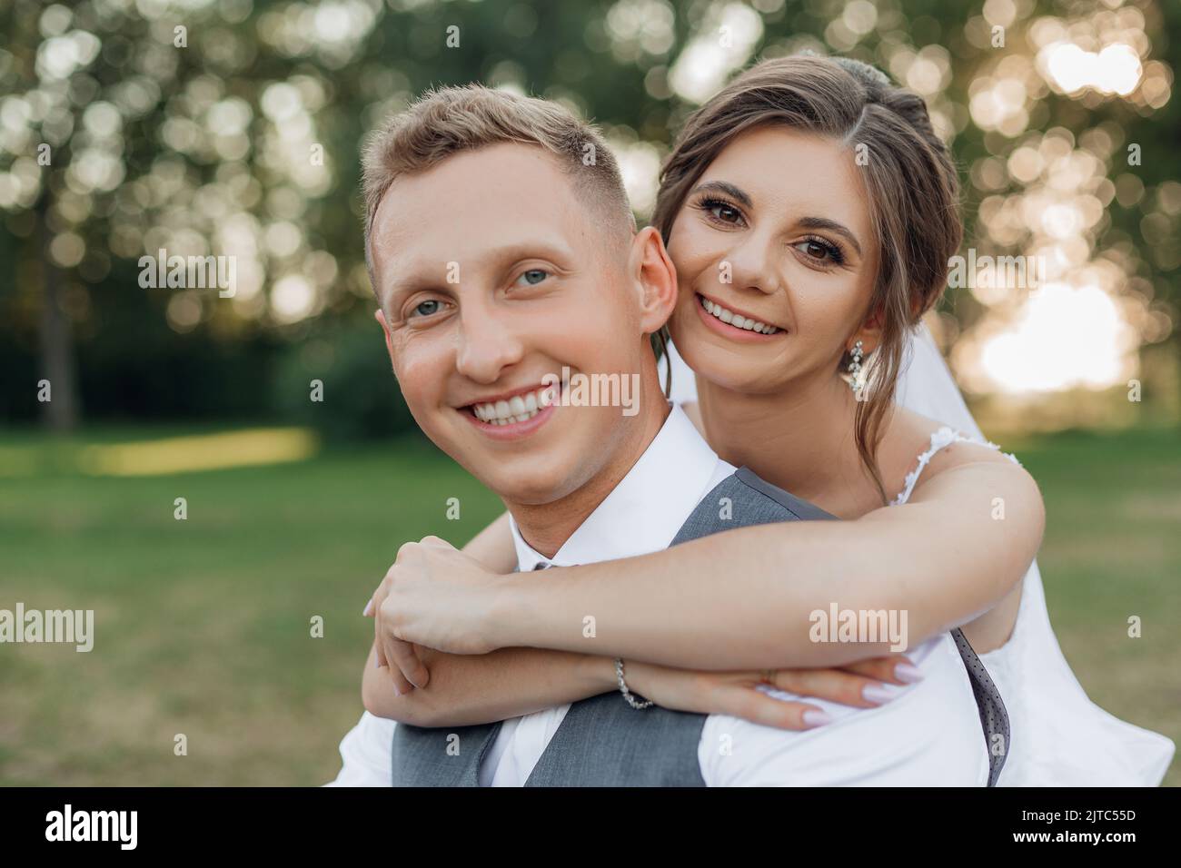 Amused, smiling newlywed married couple of bride in wedding dress and ...