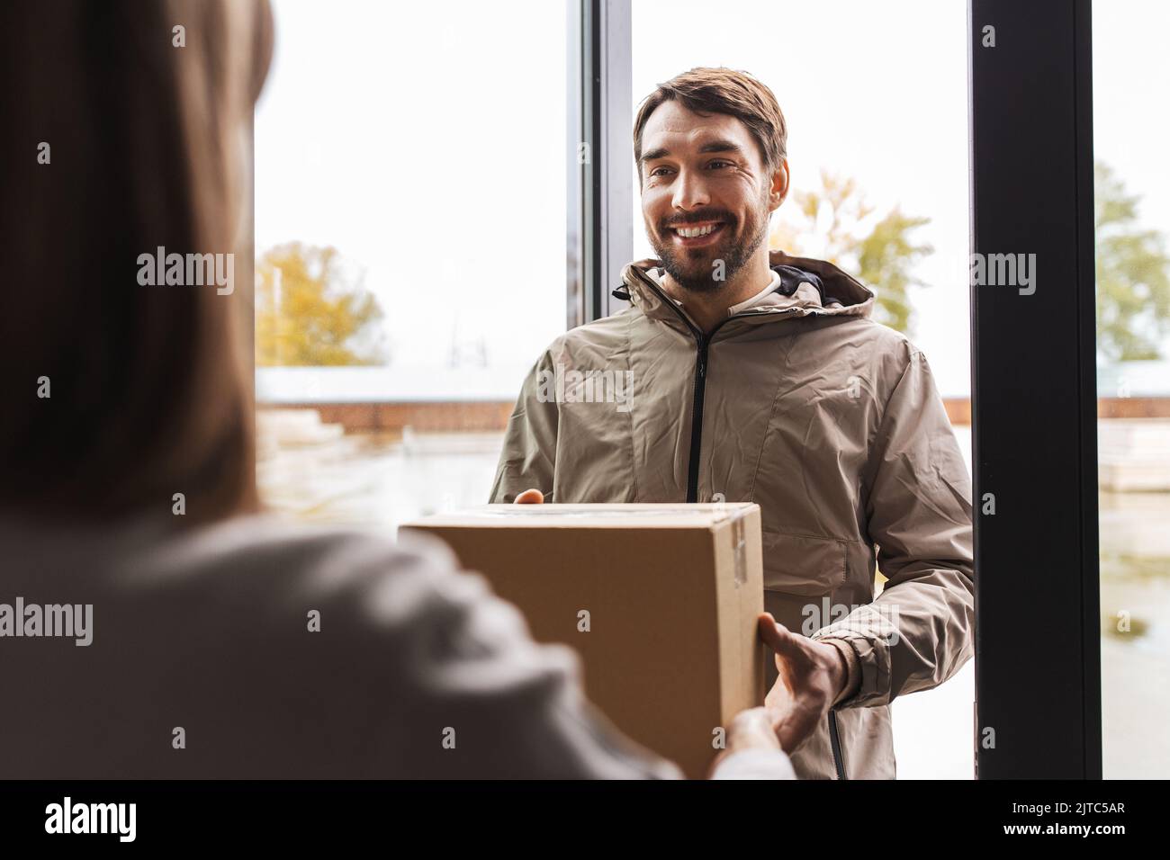 delivery man giving parcel box to customer at home Stock Photo - Alamy