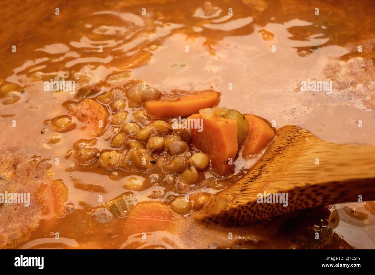 Lentil soup with carrots and onions boiling in a cooking pot Stock ...