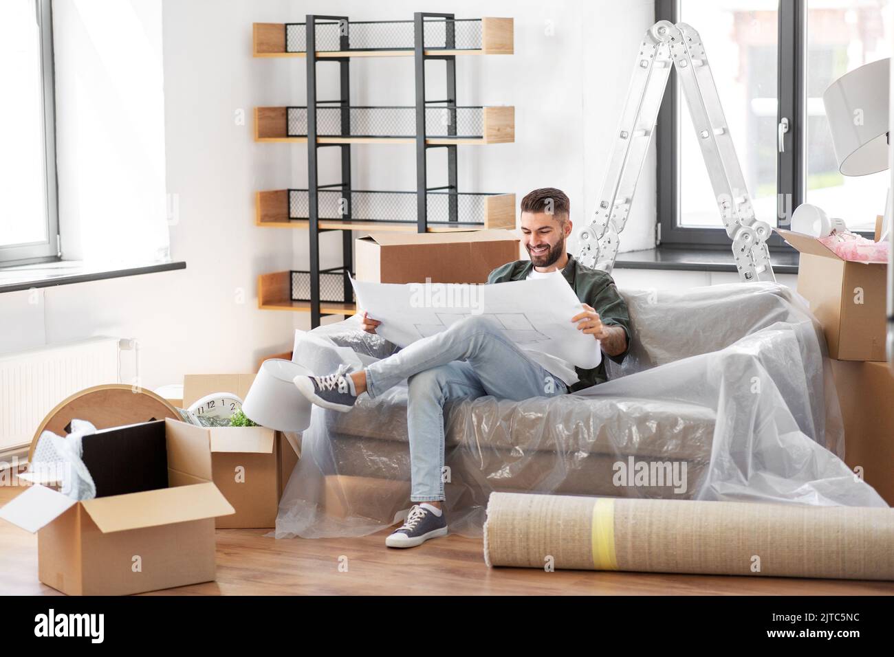 happy man with blueprint moving to new home Stock Photo - Alamy