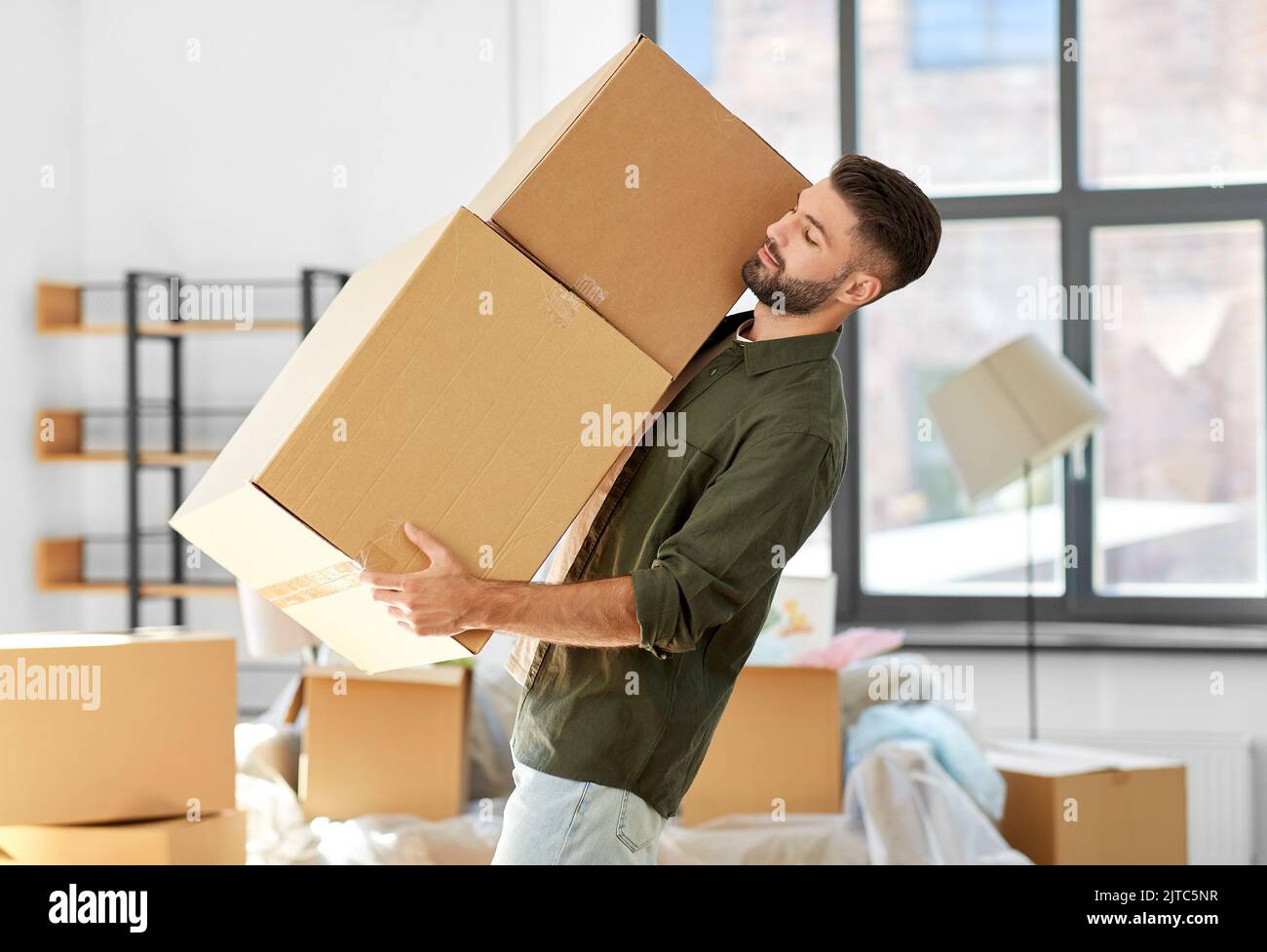 happy man with boxes moving to new home Stock Photo - Alamy