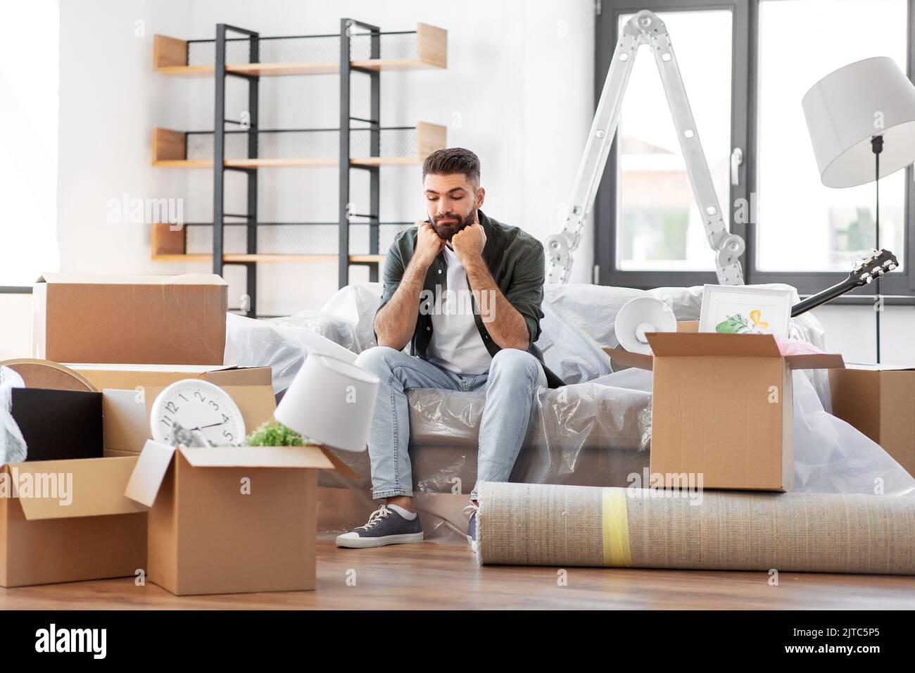 sad man with boxes moving to new home Stock Photo - Alamy