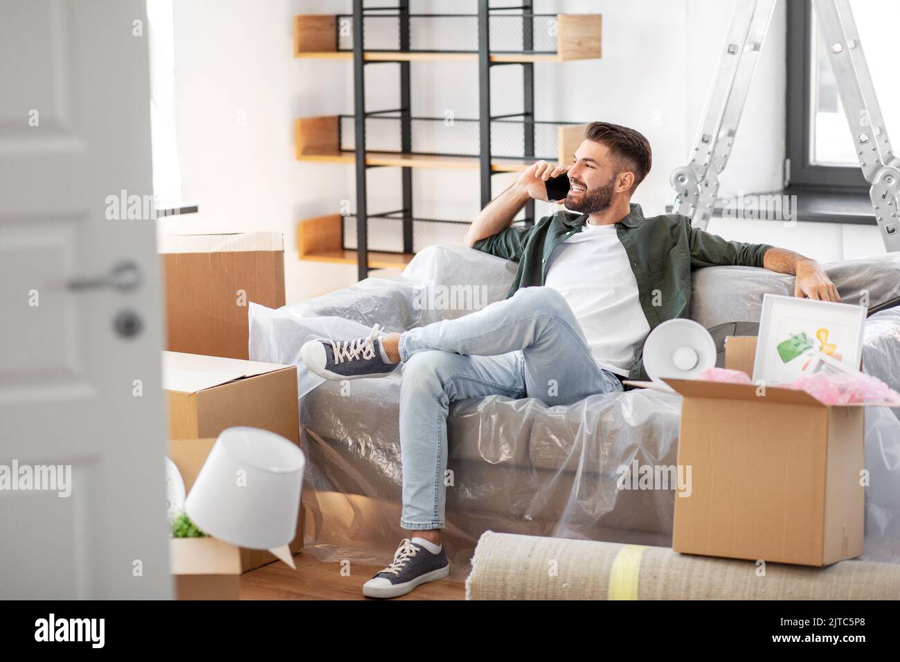 happy man calling on smartphone moving to new home Stock Photo - Alamy