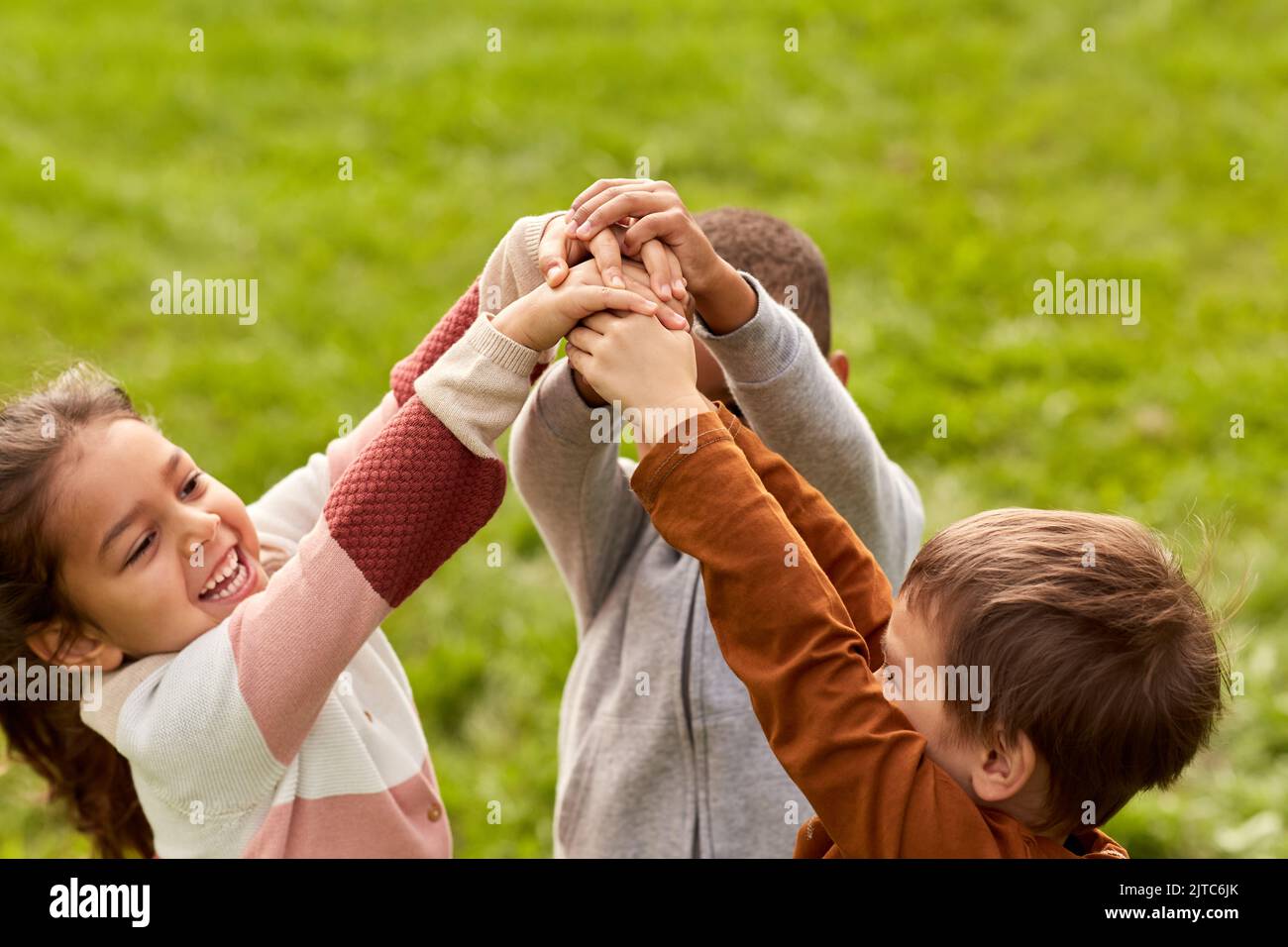 happy children playing and stacking hands at park Stock Photo - Alamy