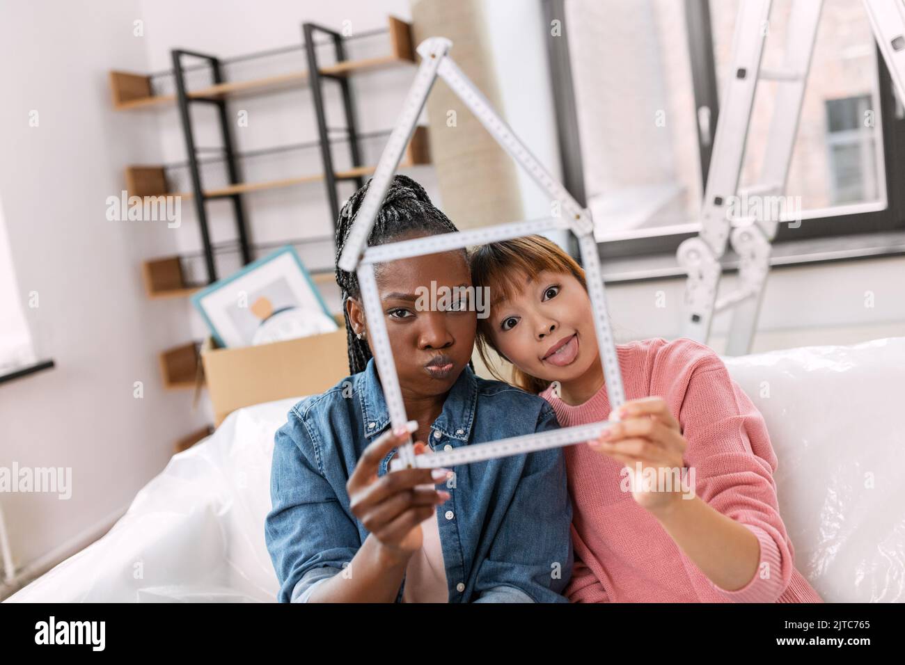 women with ruler in shape of house making faces Stock Photo - Alamy