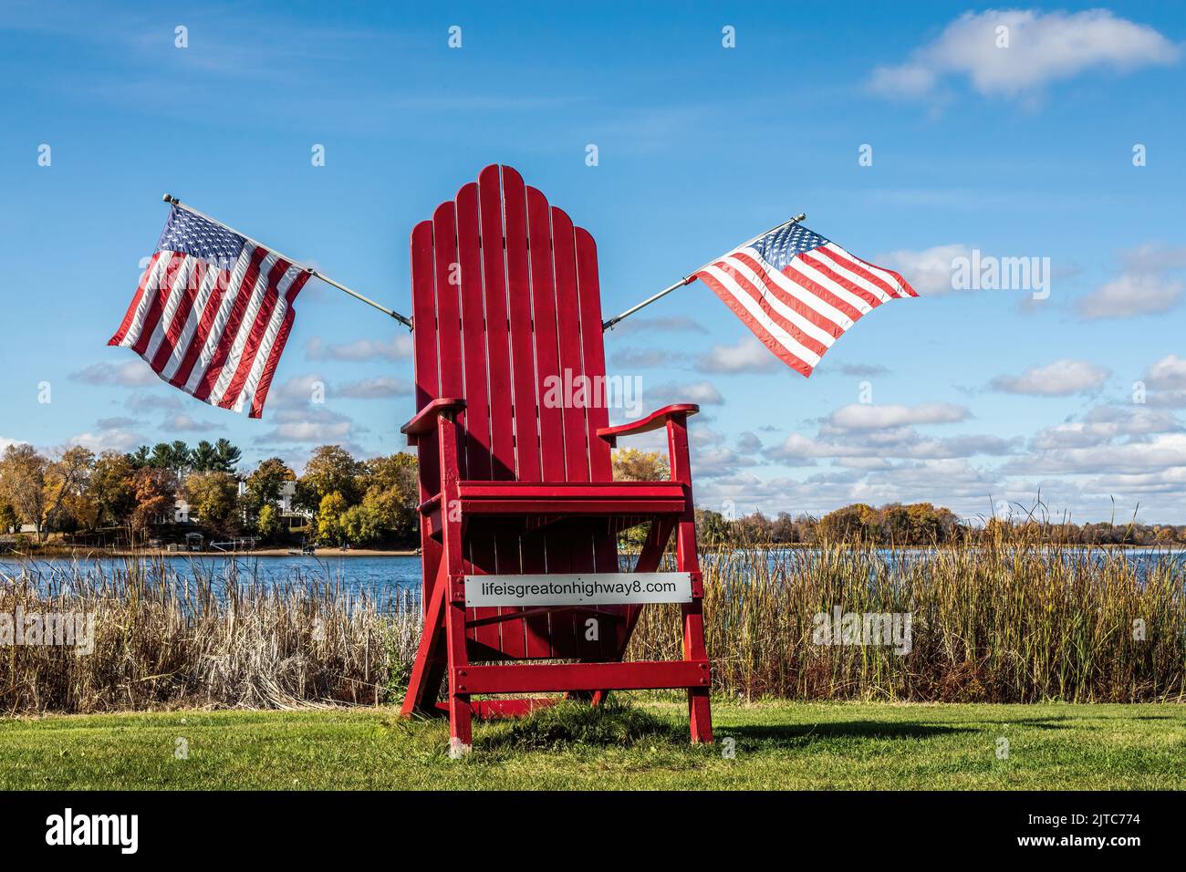 Big red adirondack chair with two American flags in front of North ...