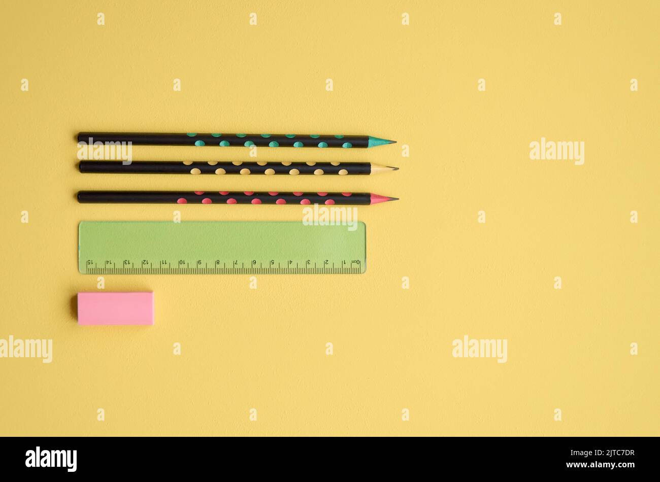 Pencils, ruler and rubber on yellow background, flatlay. Back to school ...
