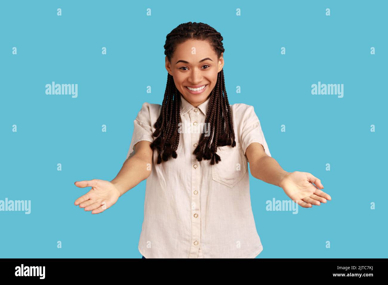 Please, take it. Portrait of kind generous woman with black dreadlocks ...