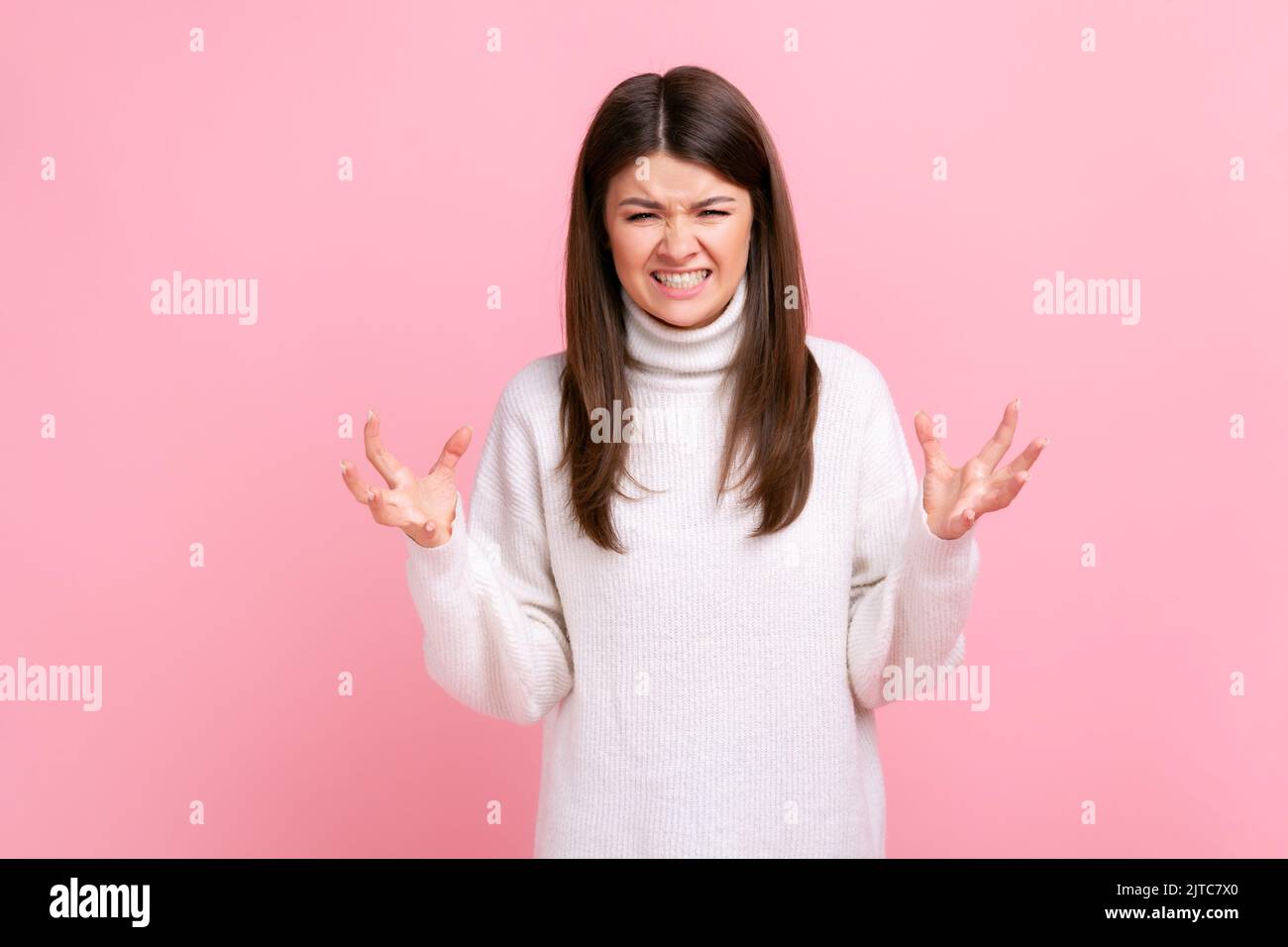 Portrait of angry female standing with raised arms, expressing ...