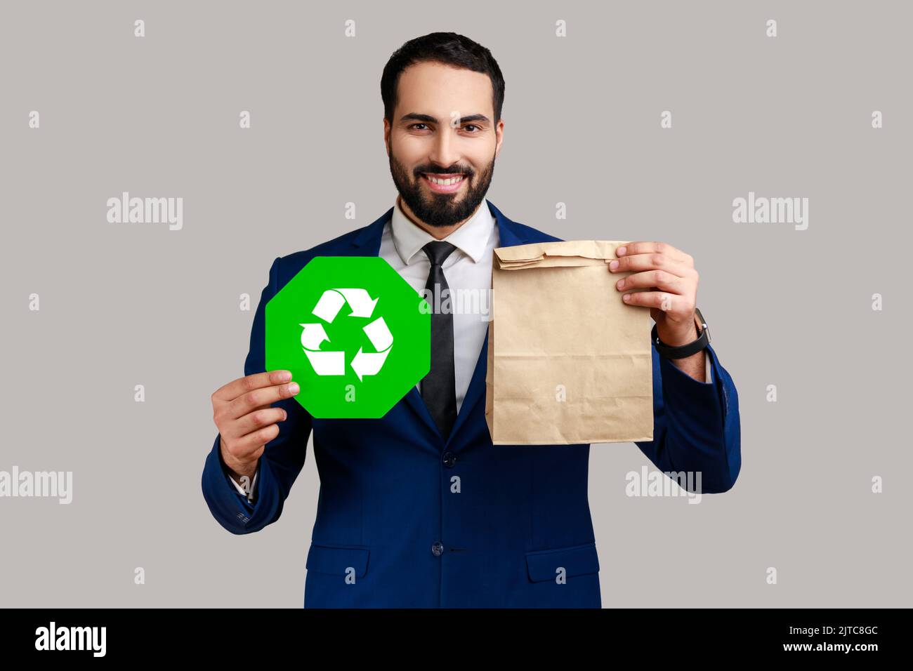 Portrait of smiling bearded man holding green recycling sign in hand ...
