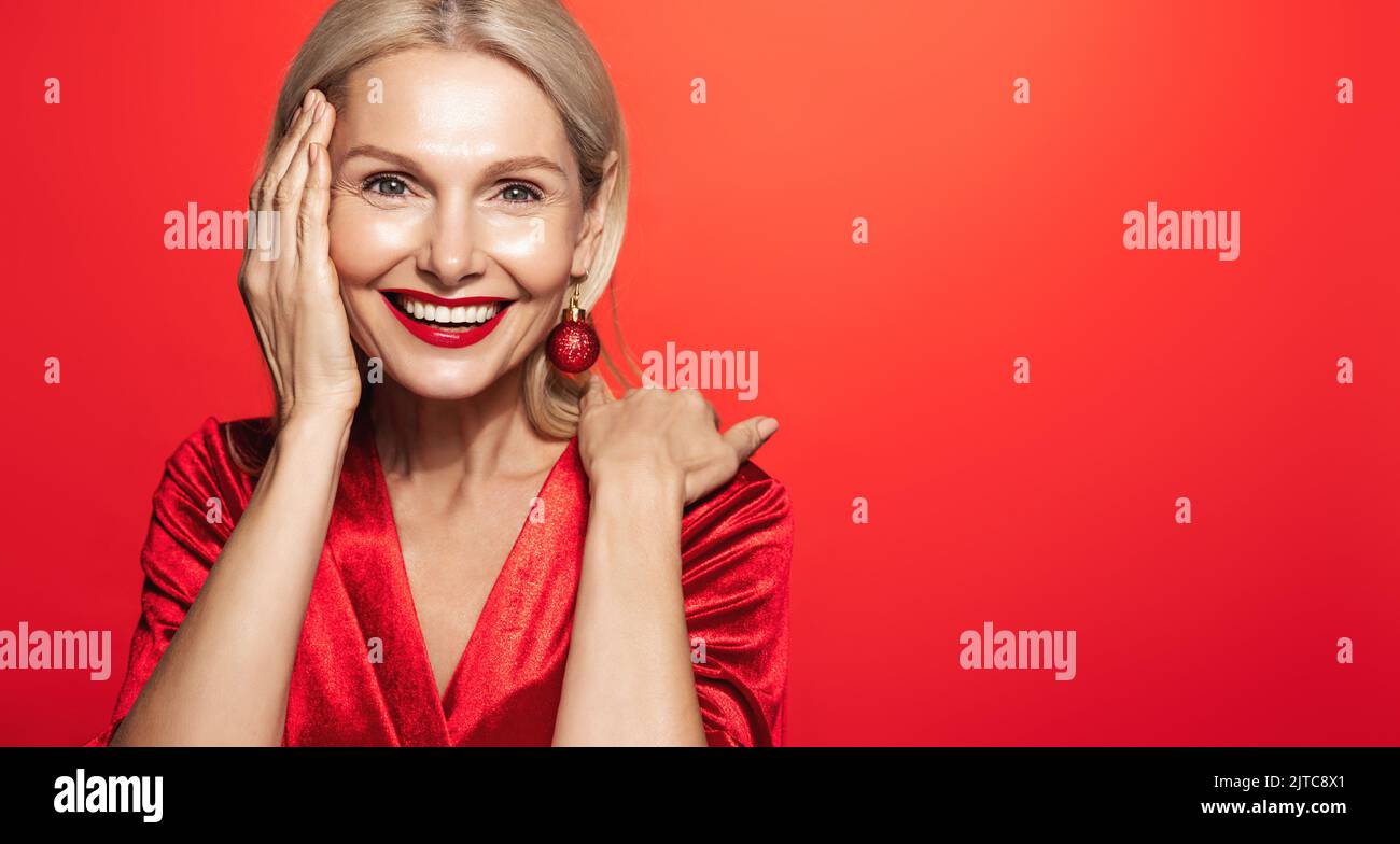 Gorgeous Middle Aged Woman In Dress And Earrings Smiling And Looking